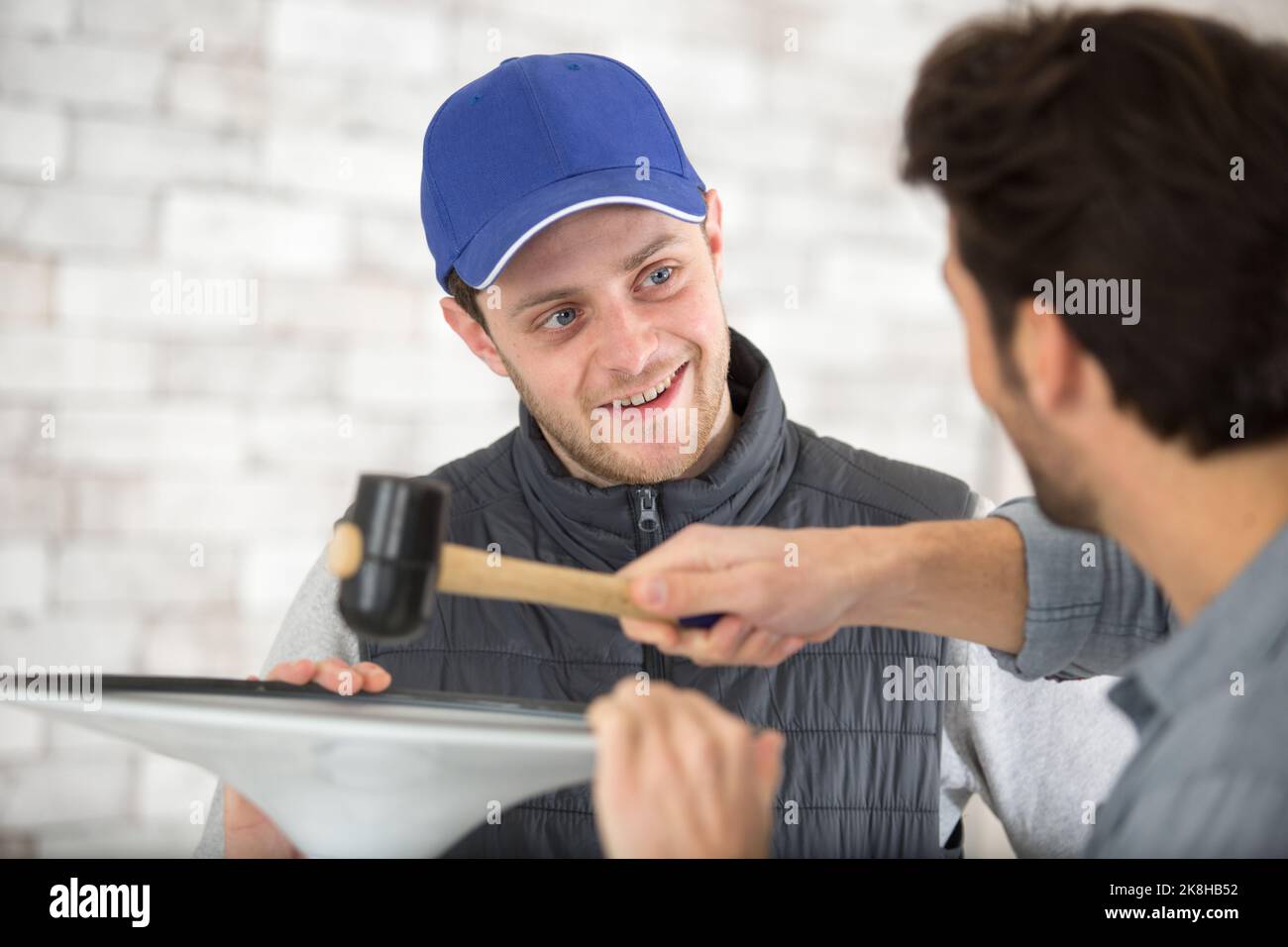 handyman and apprentice repairing a chair base Stock Photo - Alamy