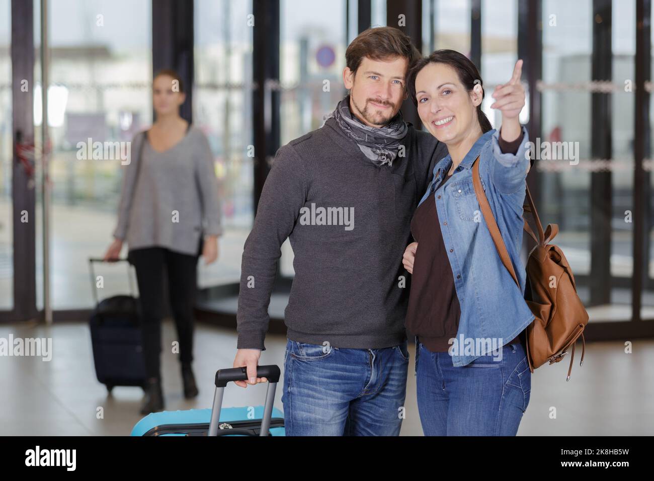 couple carrying luggage and holding hands Stock Photo - Alamy