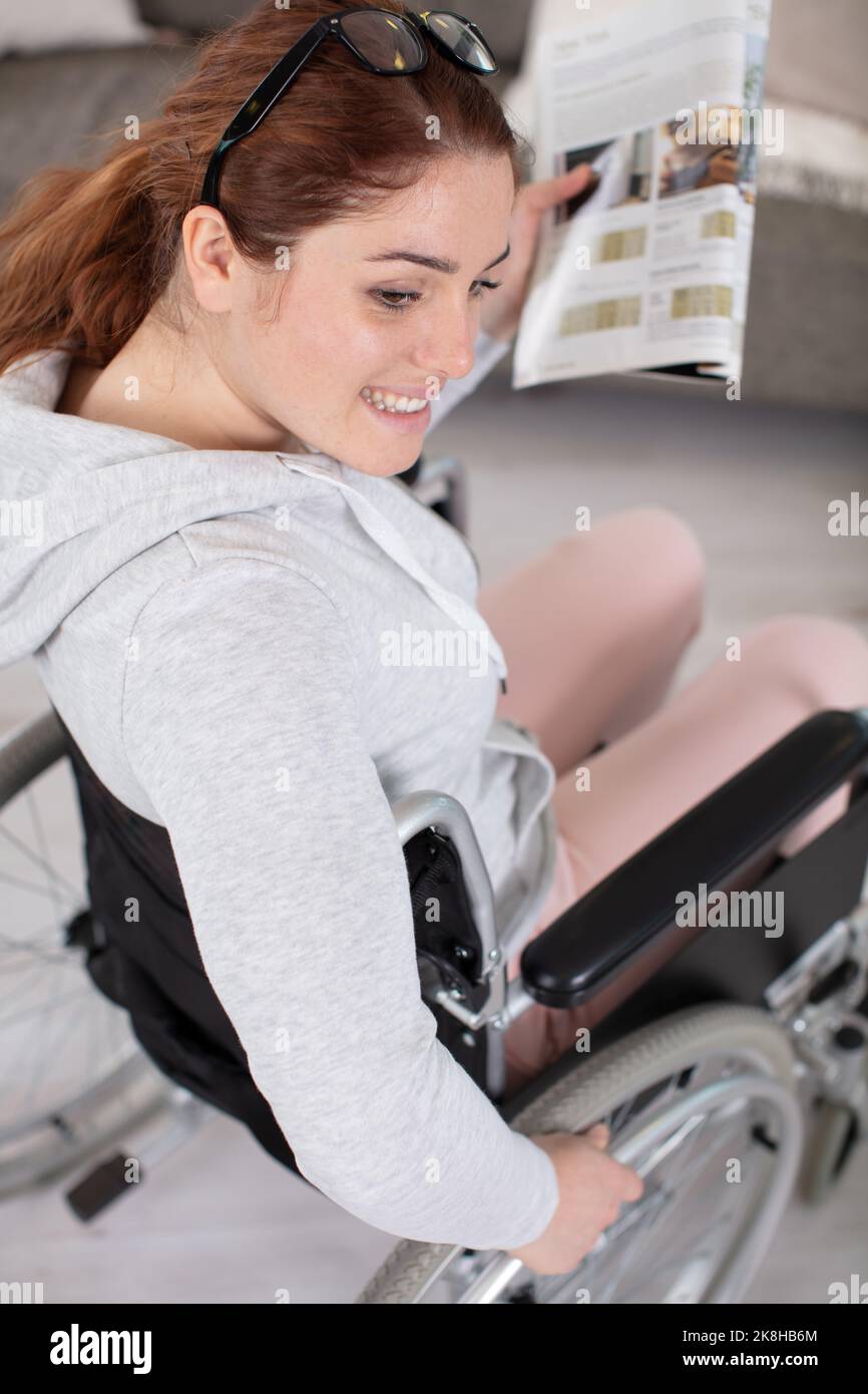 beautiful disabled woman sitting in wheelchair and holding a magazine ...