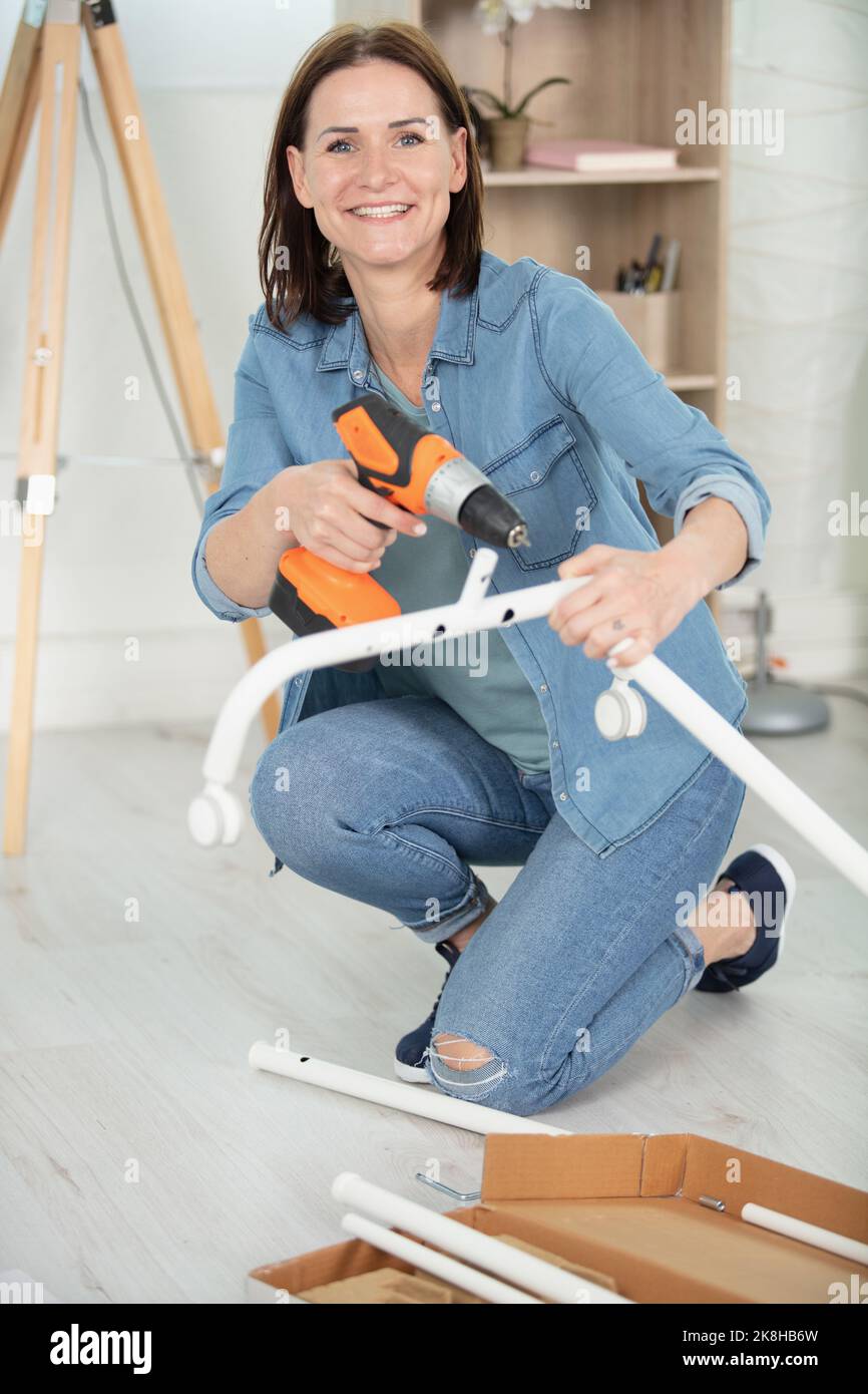 happy female carpenter at work using hand drilling machine Stock Photo - Alamy