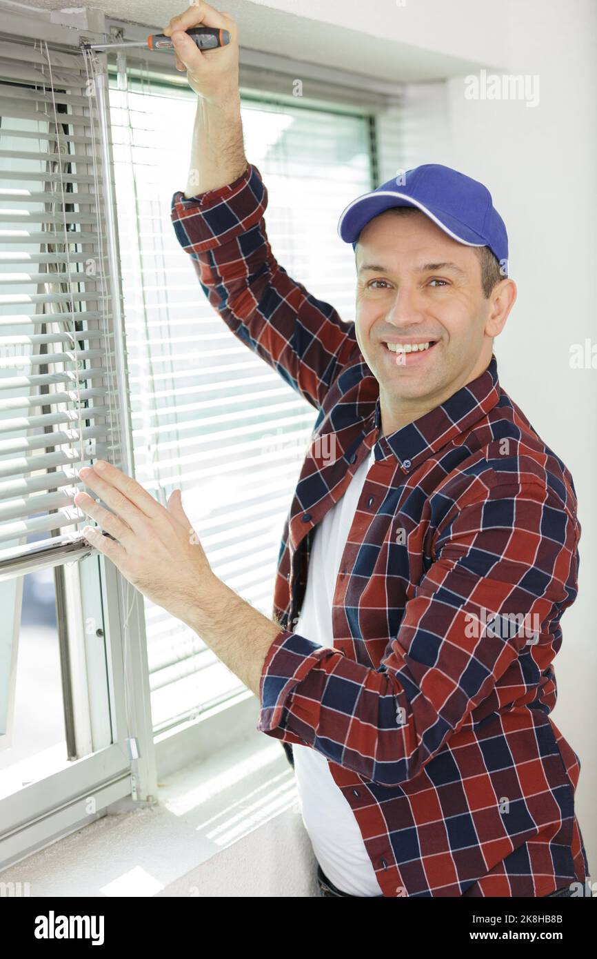 a contractor installing window blinds Stock Photo - Alamy