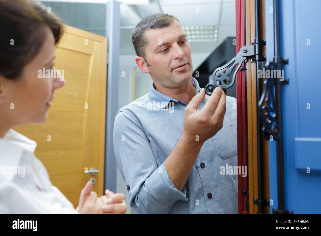 couple standing next to showcase with the door handles Stock Photo - Alamy