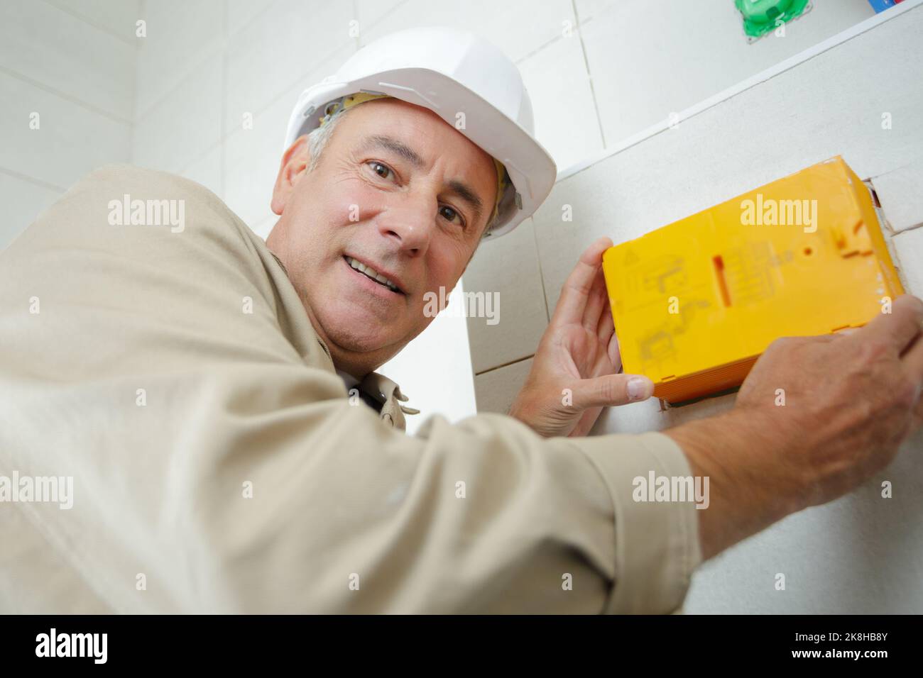 engineer in white helmet installing a control box Stock Photo - Alamy