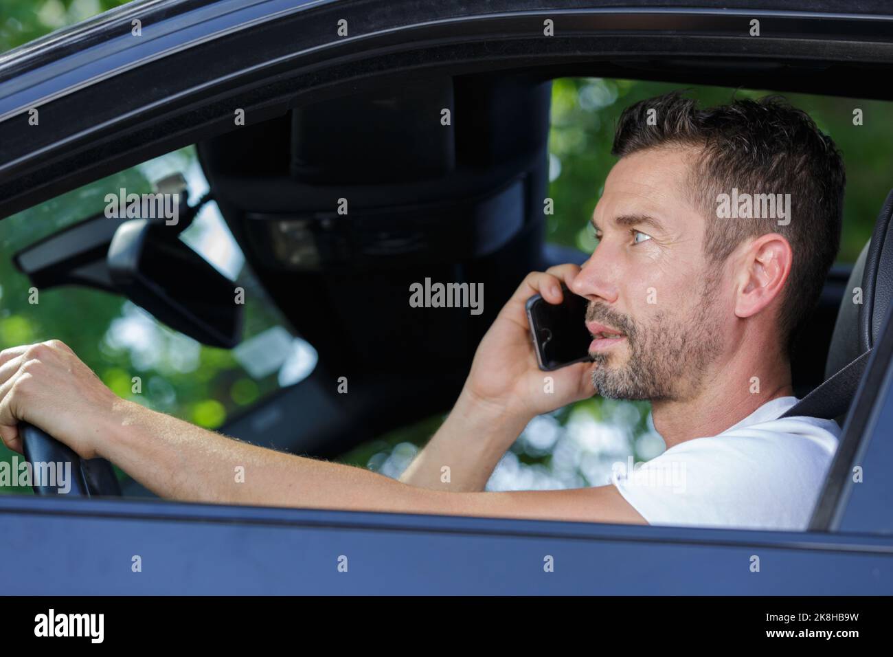 man driving car while using mobile phone Stock Photo - Alamy