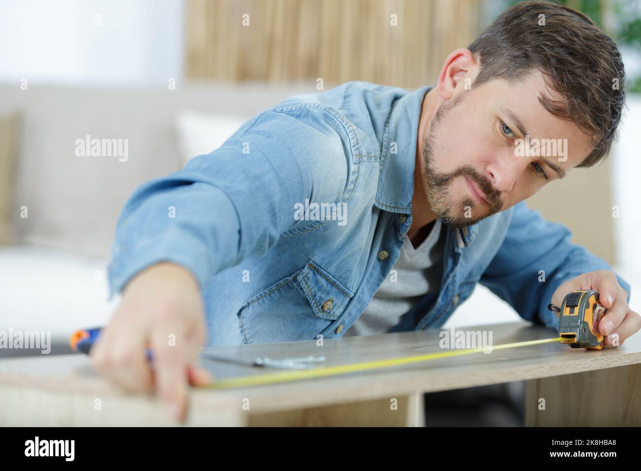 young man constructing and measuring wood Stock Photo - Alamy