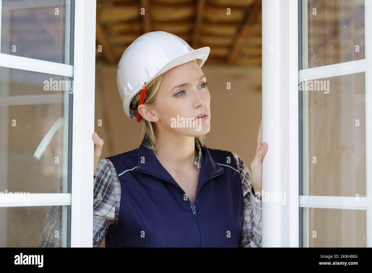 young woman builder looking outside of the window Stock Photo - Alamy