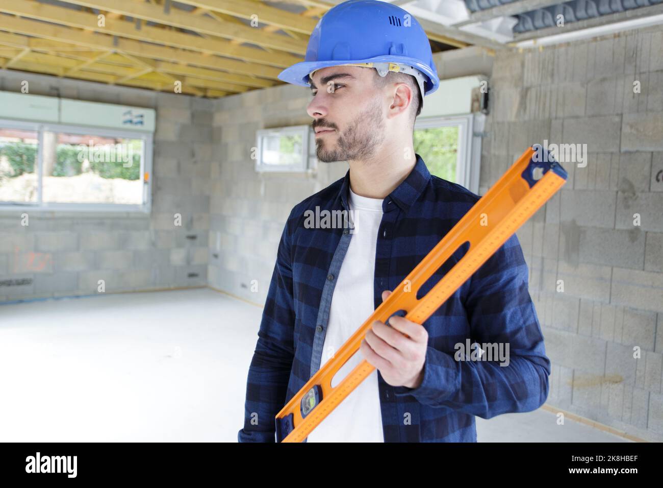 a builder on site with spirit level Stock Photo - Alamy