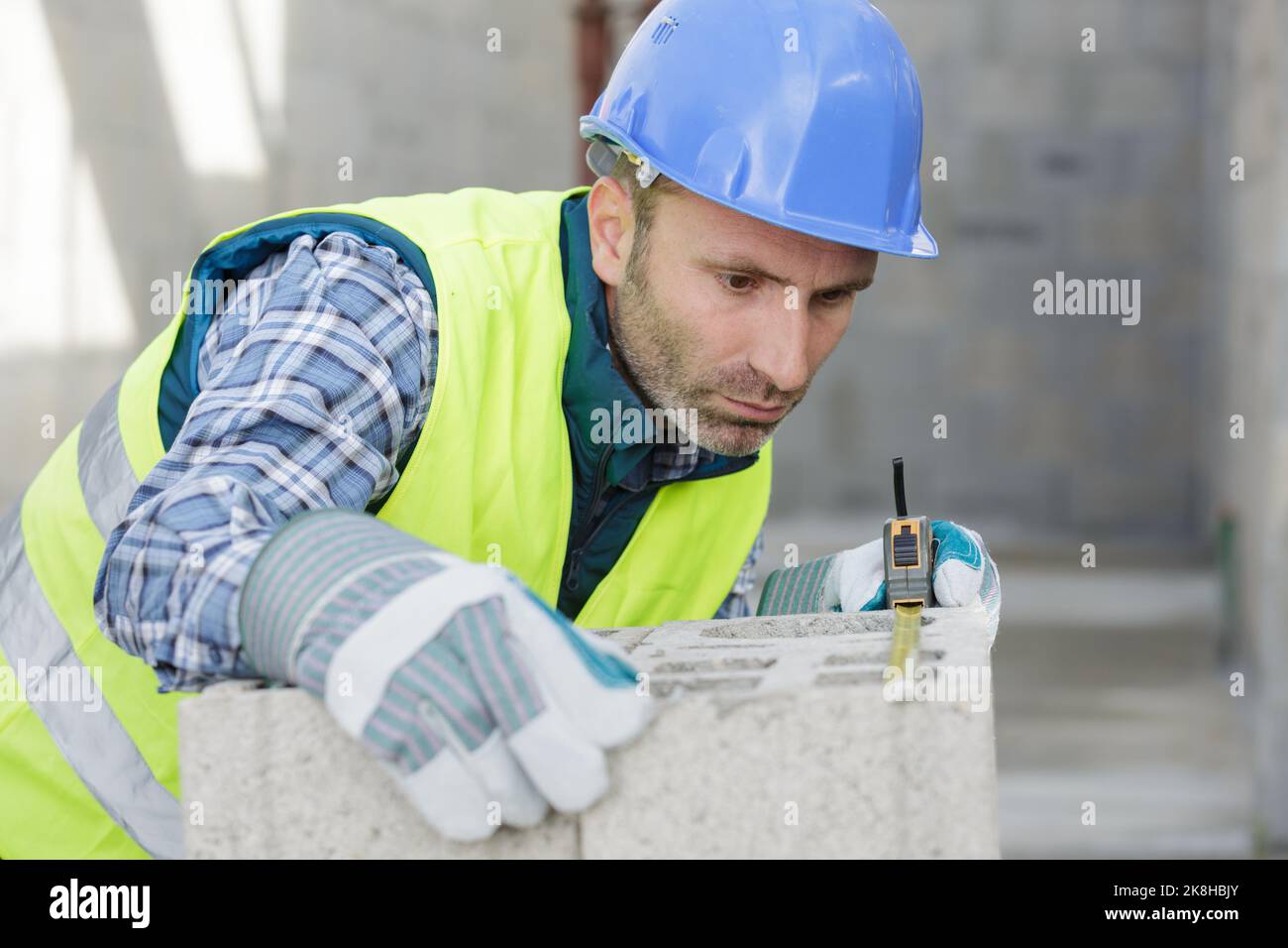 master in the working overalls measures a block Stock Photo - Alamy