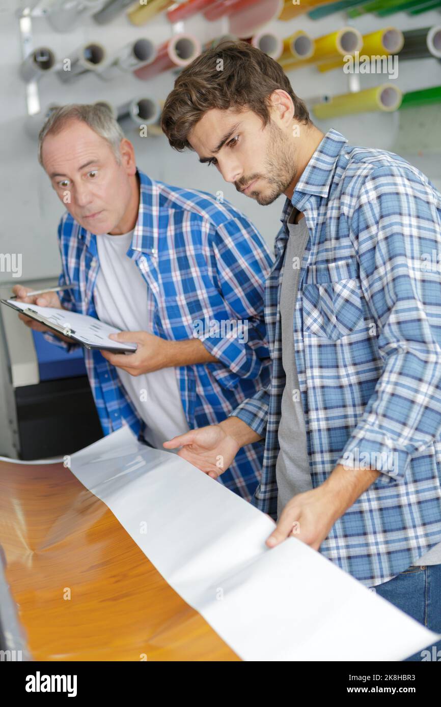 man checking paper et professional printing machine Stock Photo - Alamy