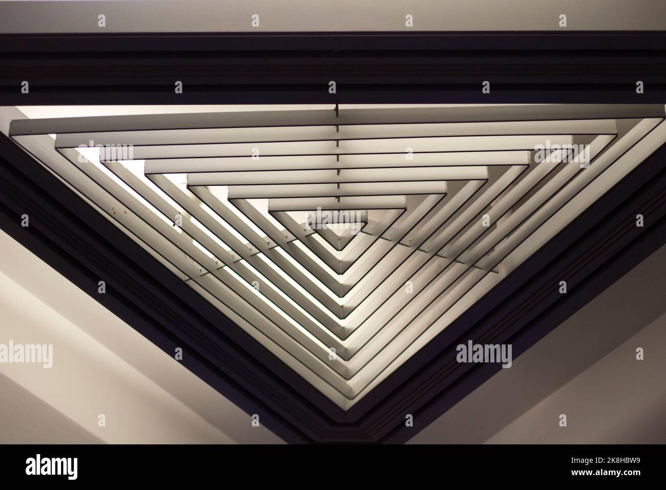 Triangular lamp in interior. Design of lighting device. Lamp on ceiling ...