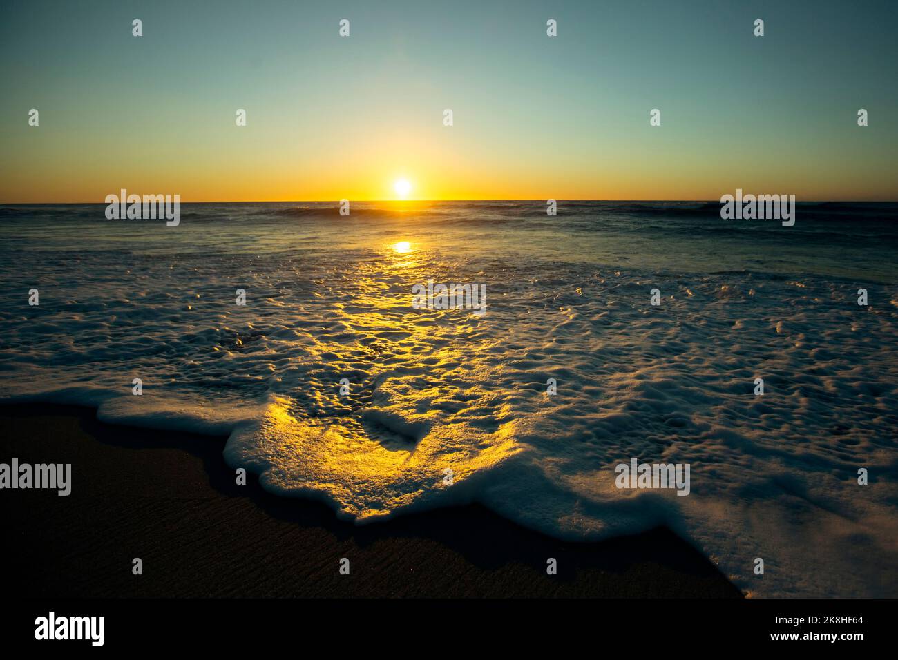 Foamy surf during golden sunset on the Atlantic coast Stock Photo - Alamy