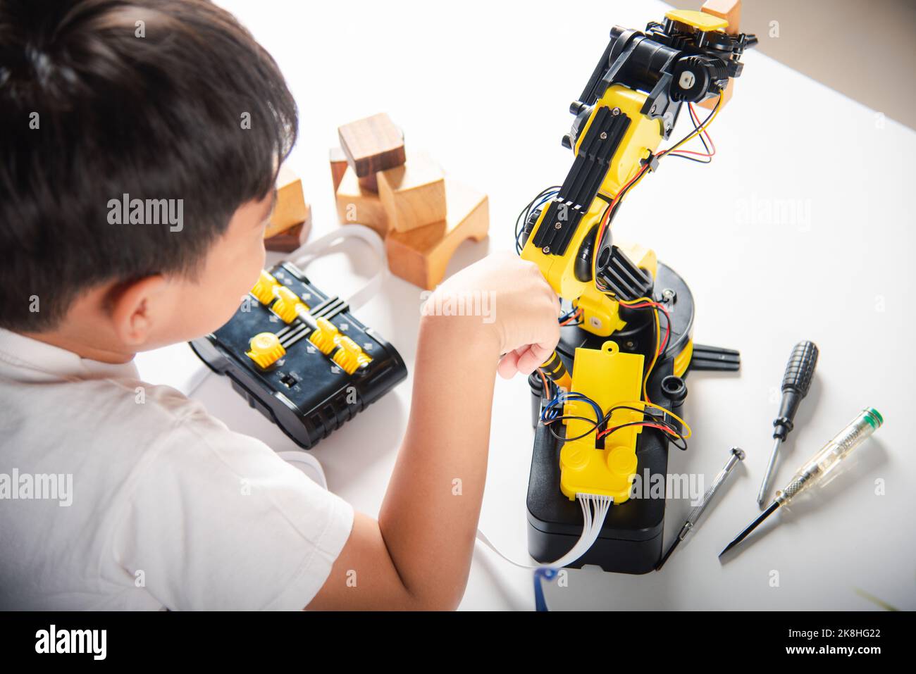 Happy Asian little kid boy using screwdriver to fixes screws robotic ...