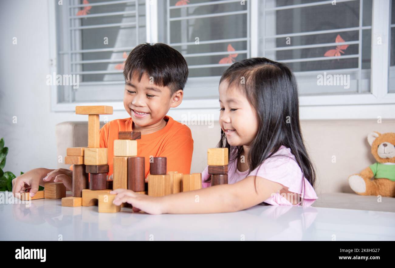 Happy little kids play wood block stacking board game at home, Children ...