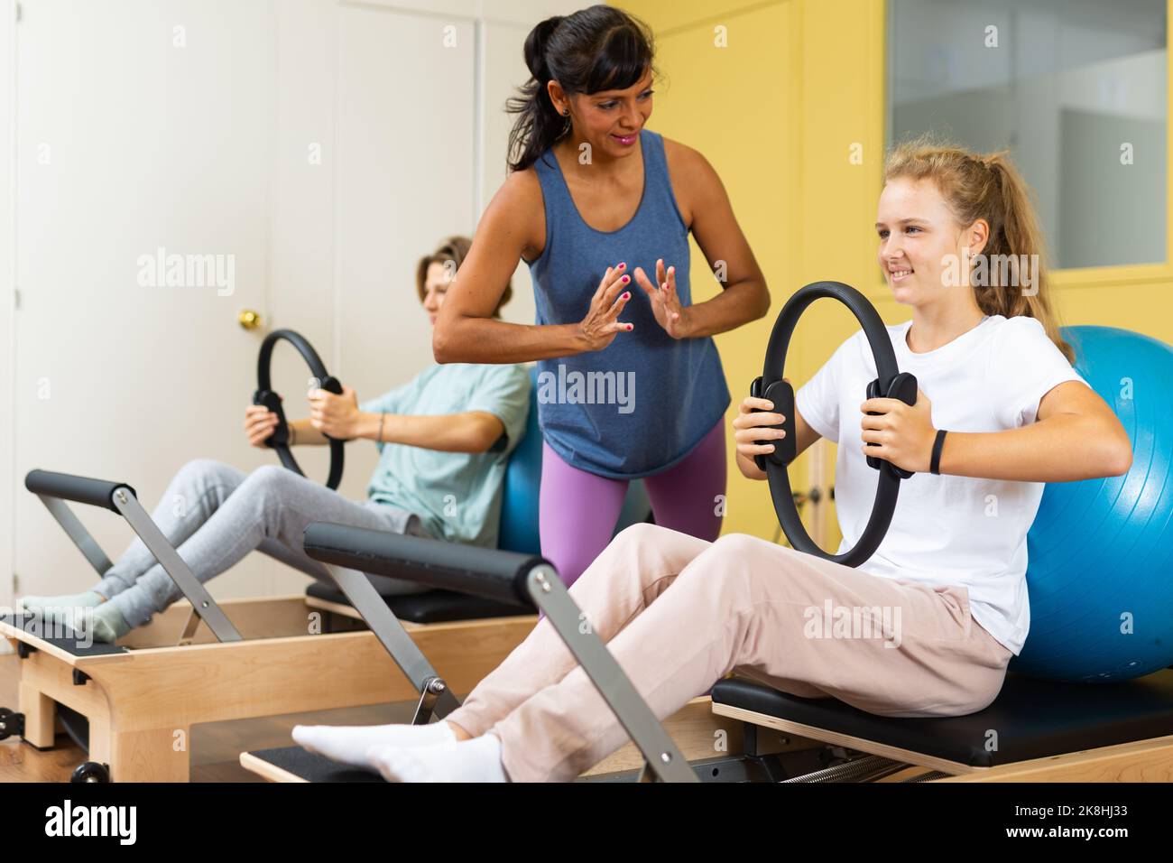 Teenagers training pilates in gym with trainer Stock Photo - Alamy