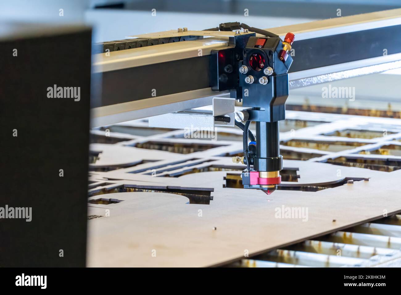 laser cutting machine, cutting wood sheets, while a man takes care of ...