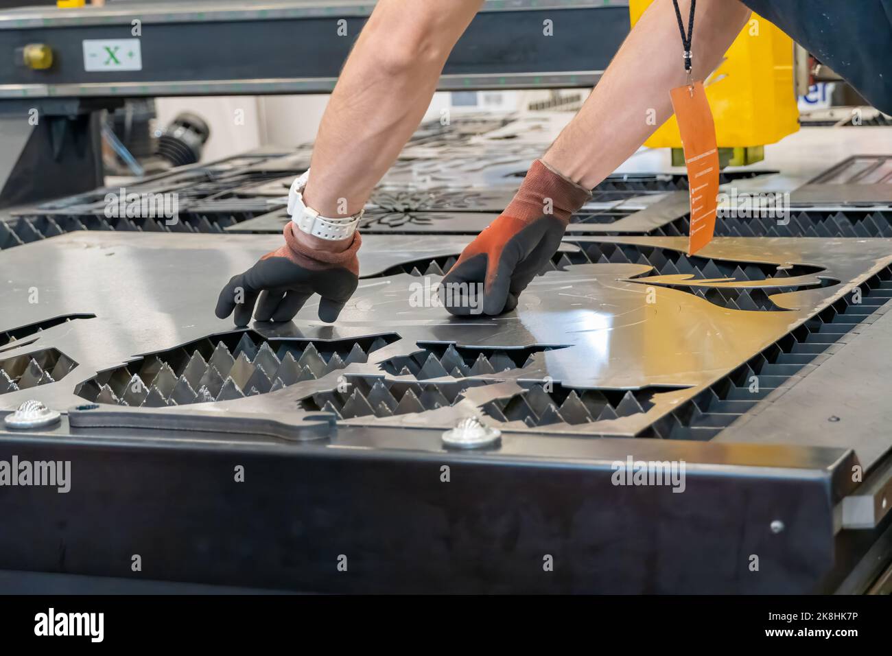 laser cutting machine, cutting wood sheets, while a man takes care of ...