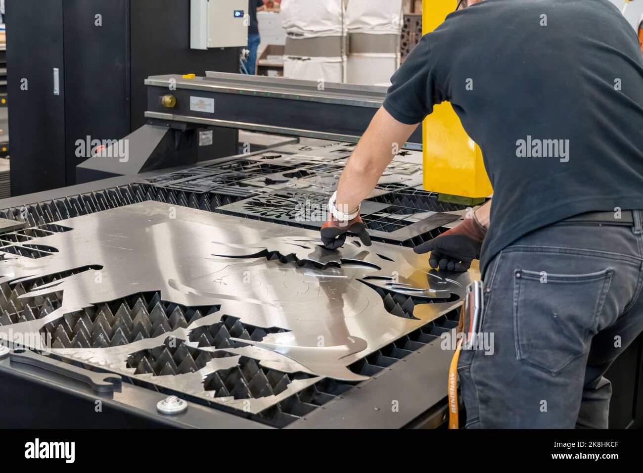 laser cutting machine, cutting wood sheets, while a man takes care of ...