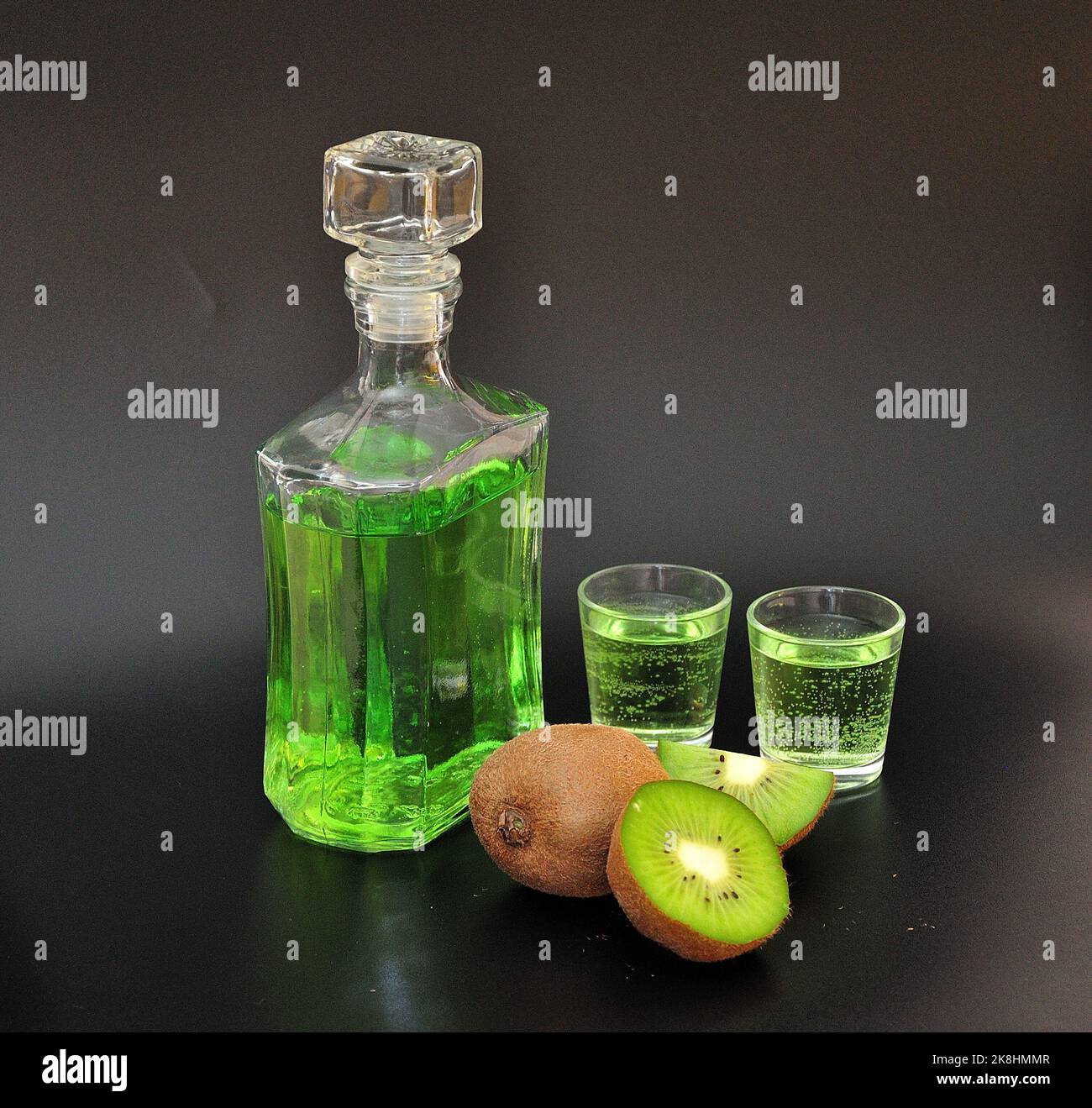 Kiwi-based liquor, homemade alcohol in a bottle and two glasses on a ...