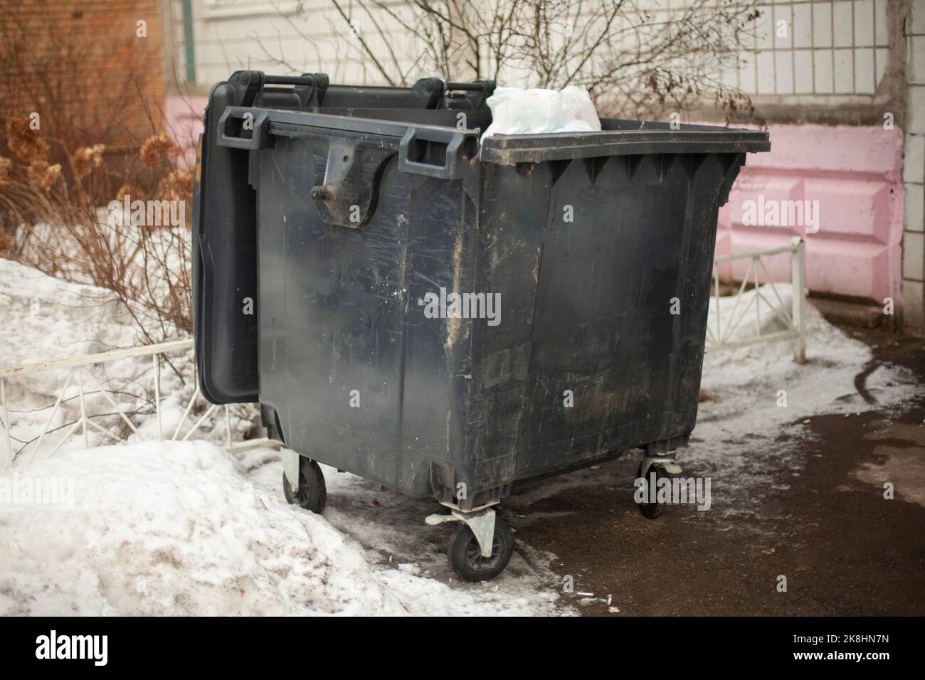 Black garbage can on street. Dirty container in ghetto. Waste garbage ...