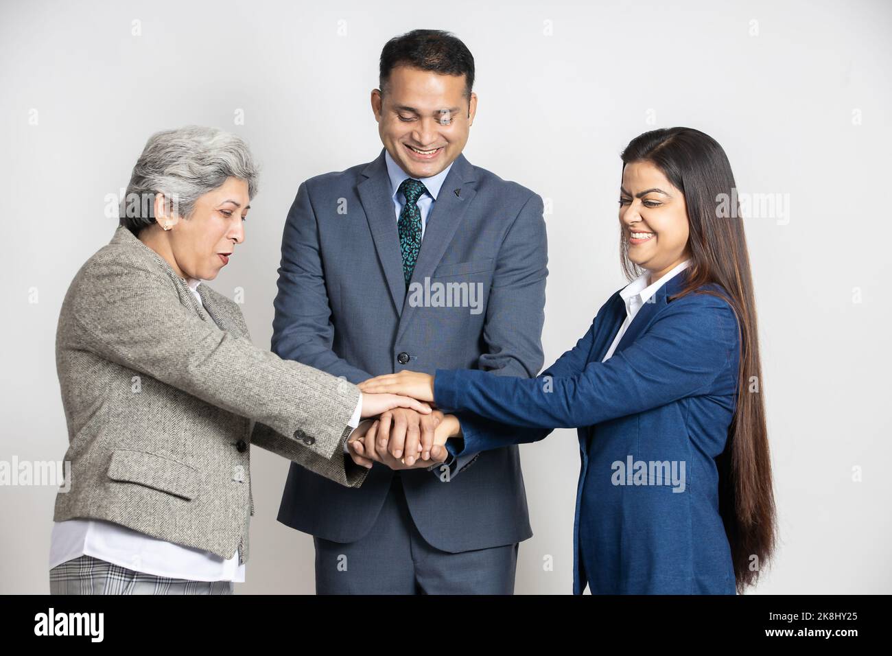 Group of positive indian business partners putting their hands together ...