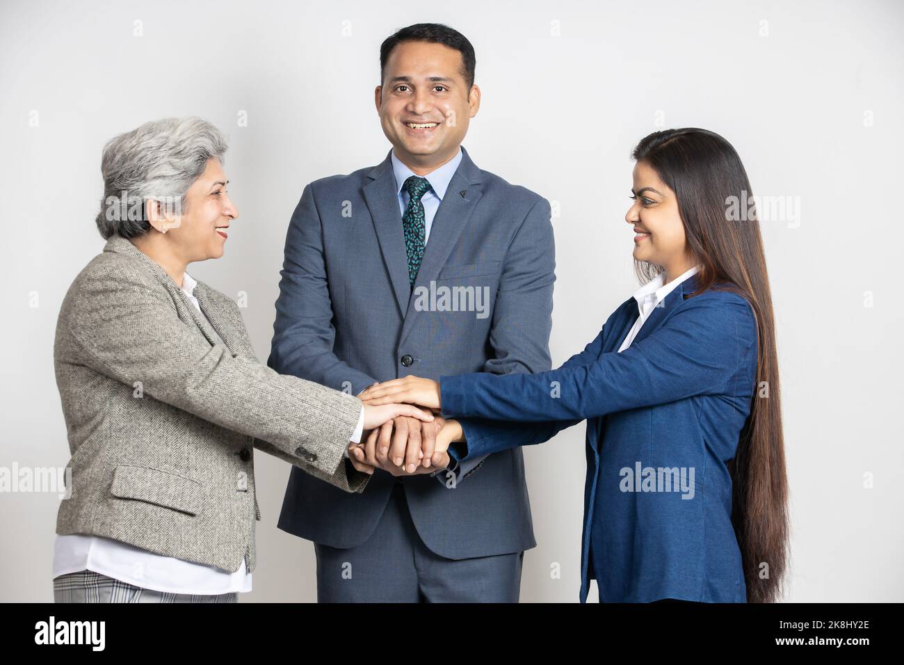 Group of positive indian business partners putting their hands together ...
