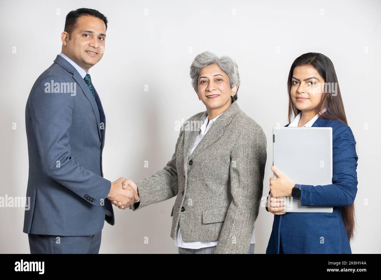 Indian senior corporate woman boss hand shake with young business man ...