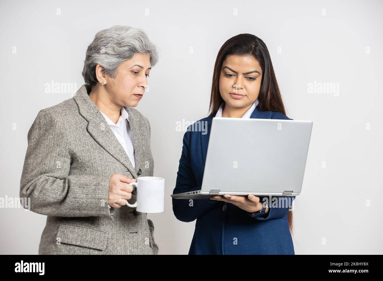 Indian senior corporate female boss and young woman partner working ...