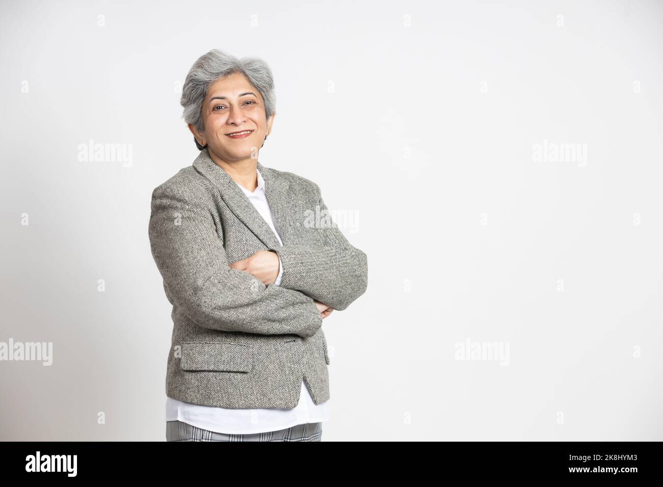 Confident Mature Senior Indian Businesswoman In A Suit Standing With His Arms Cross Isolated On