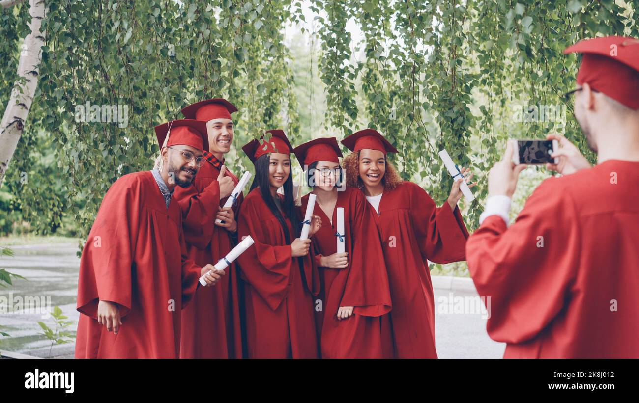 Multiethnic group of graduating students is posing for smartphone ...