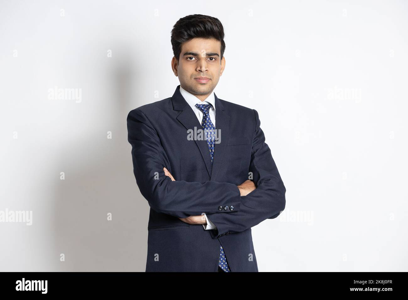 Portrait of a confident young indian man wearing suit standing with his ...