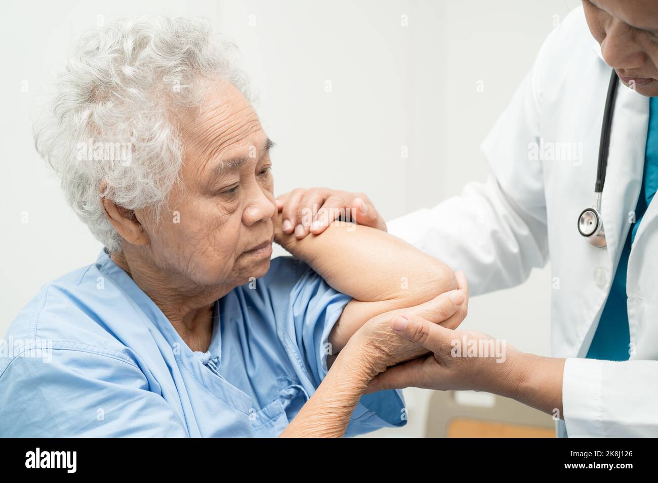Asian senior or elderly old lady woman patient feel pain her elbow on ...
