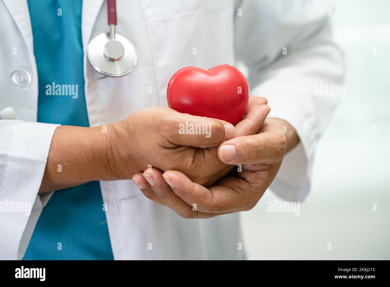 Doctor holding a red heart in hospital ward, healthy strong medical ...