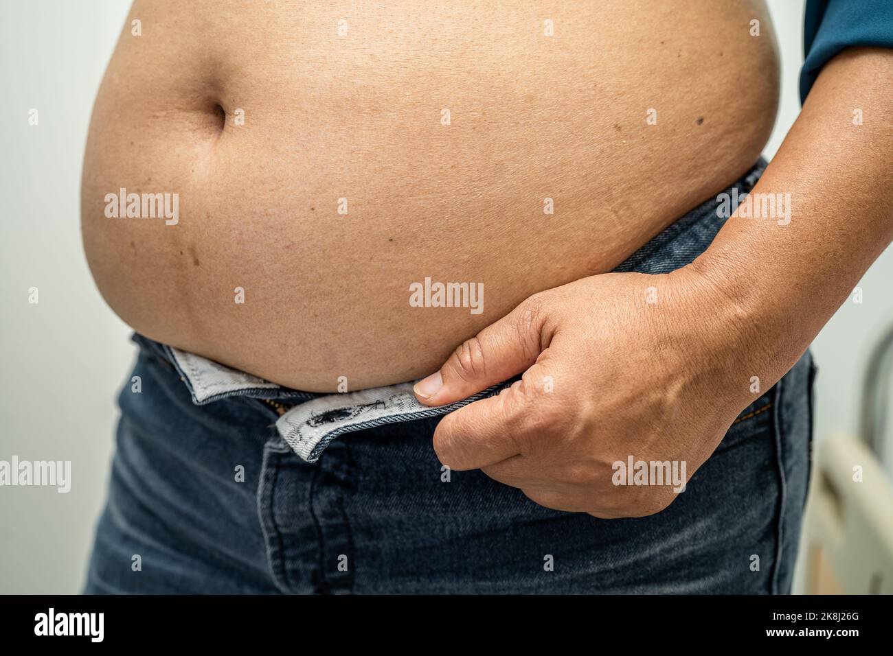 Overweight Asian woman show fat belly at office Stock Photo - Alamy
