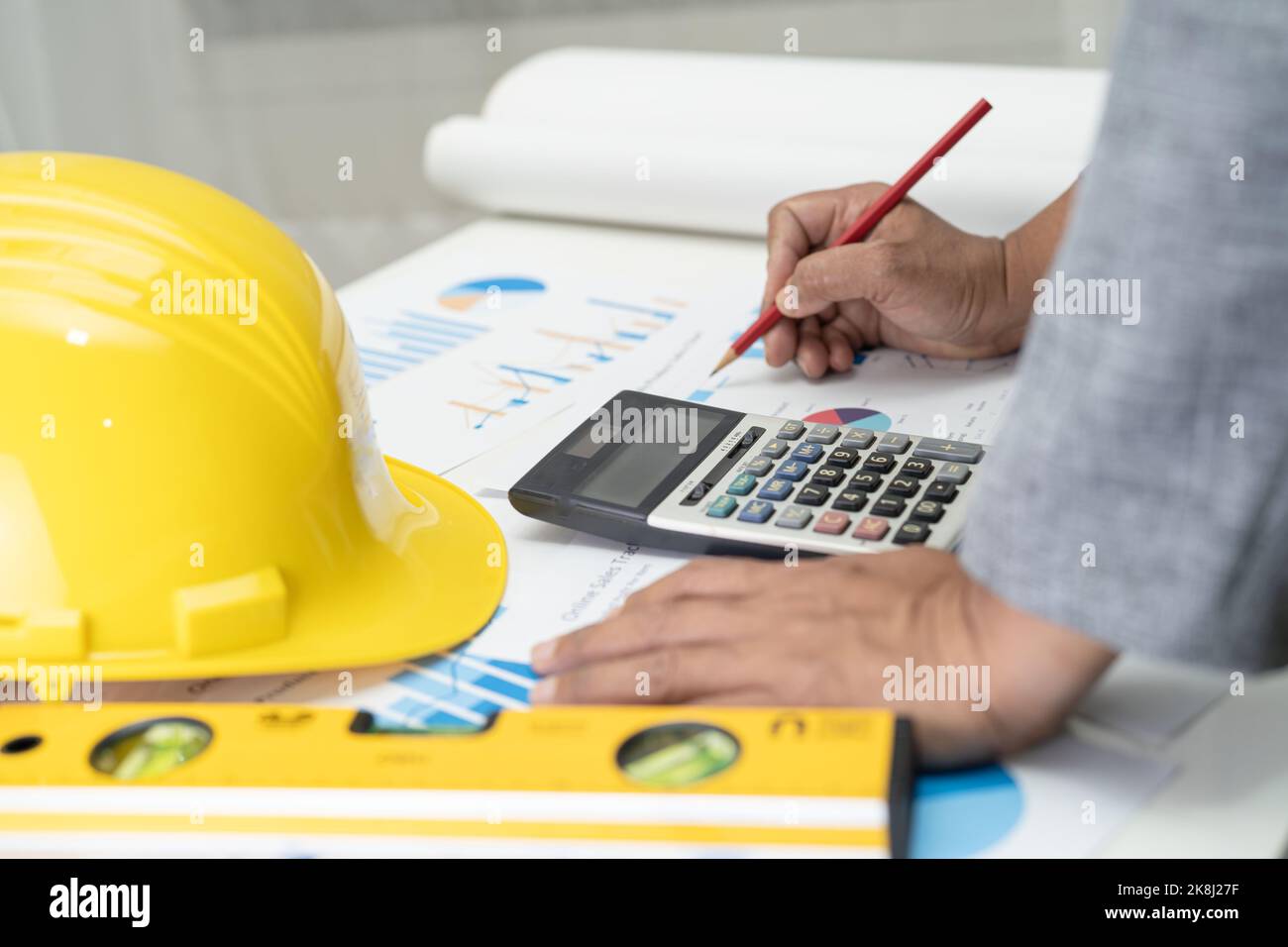 Asian engineer with architectural house plan project blueprint, graph ...