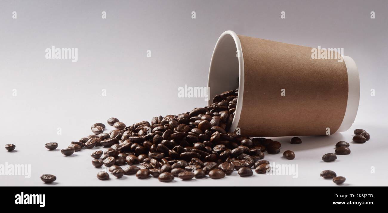 More beans, more taste. Studio shot of a tipped over paper cup filled ...