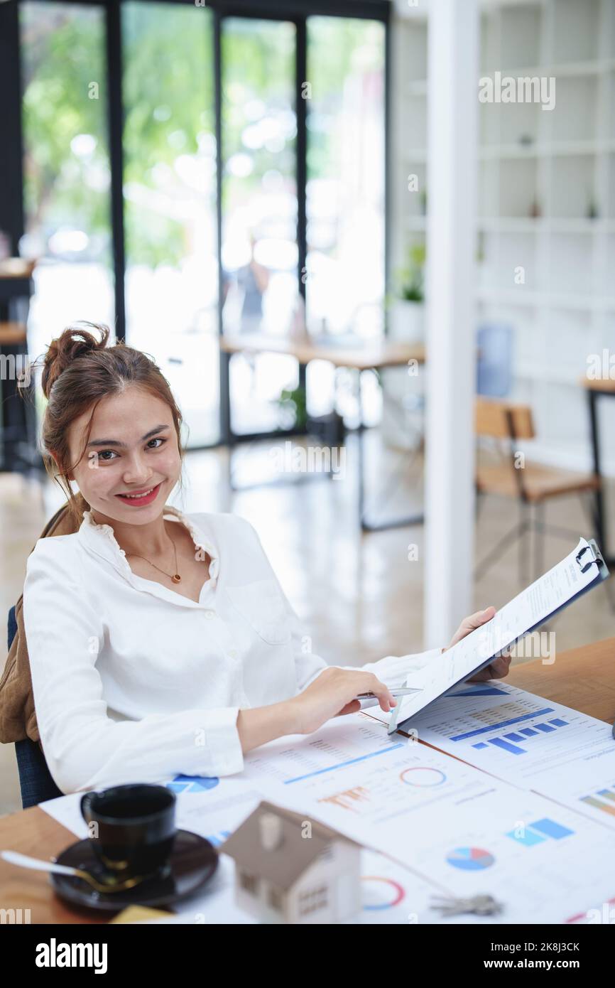 Portrait of a beautiful bank young woman sign credit department of ...