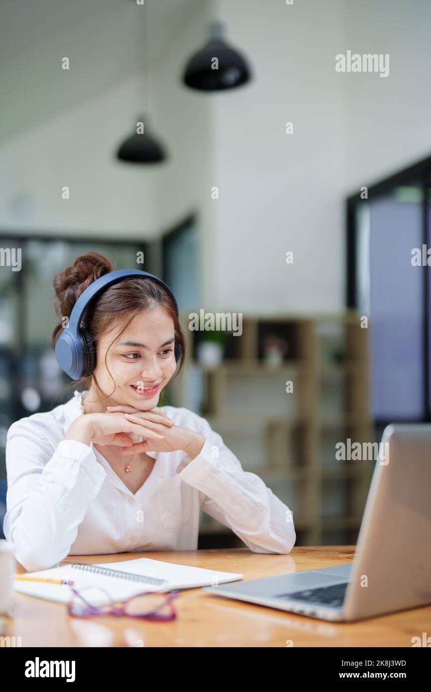 woman using a computer and earphone during a video conference Stock ...