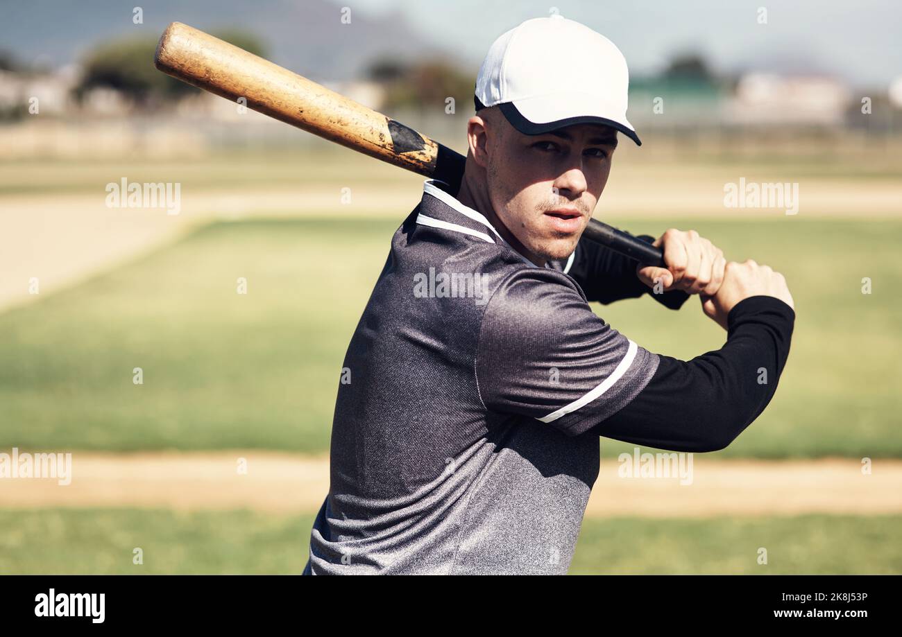 Take it from swing to win. a young man swinging his bat at a baseball ...