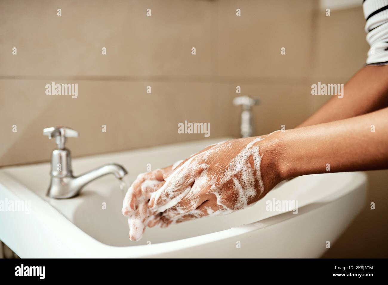 Scrub them til theyre squeaky clean. a woman washing her hands with ...