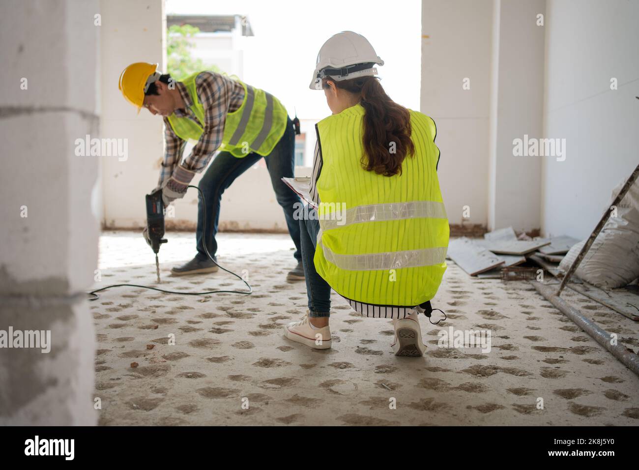 Engineer checking worker using an electric jackhammer to drill ...