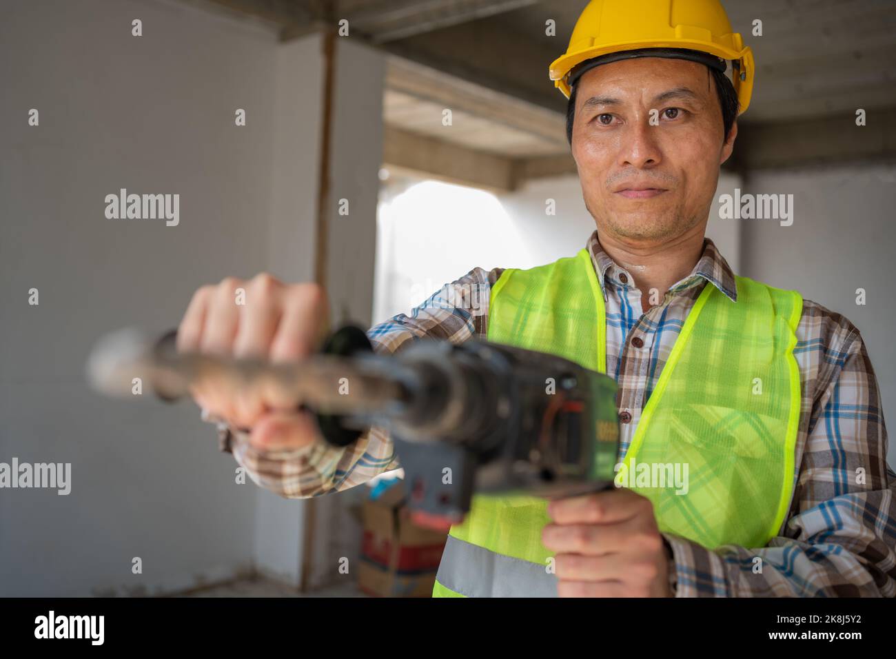 Construction worker Using an electric jackhammer to drill perforator ...