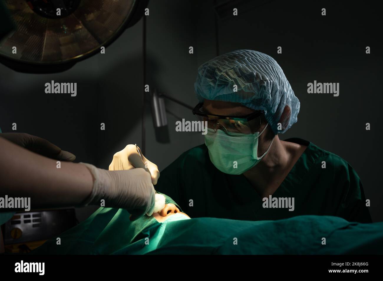 Asian Professional surgeons team performing surgery in the operating ...