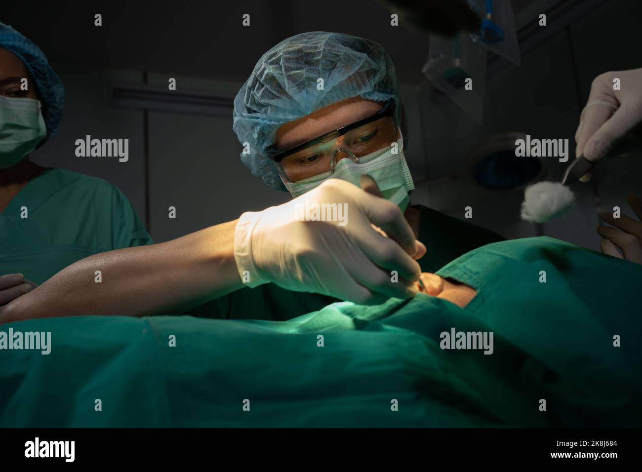 Asian Professional surgeons team performing surgery in the operating ...