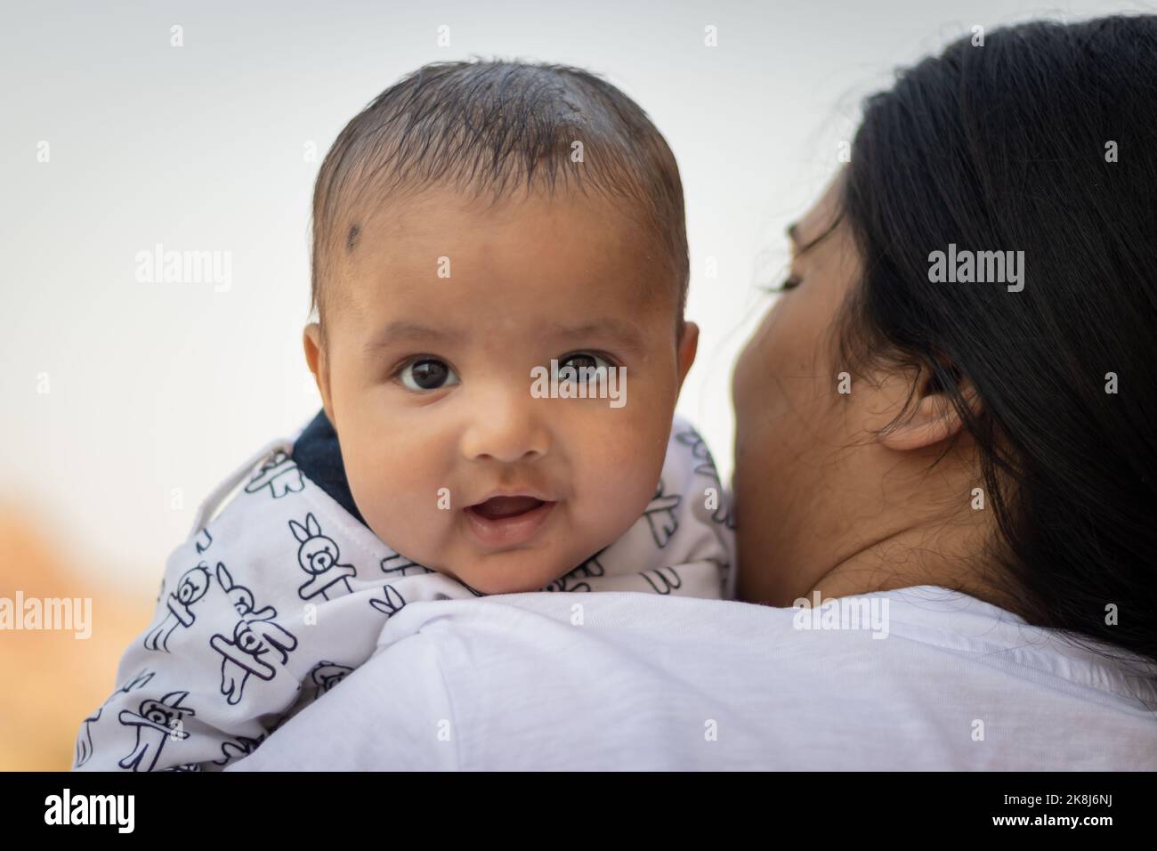 cute infant facial expression resting at mother shoulder from flat ...