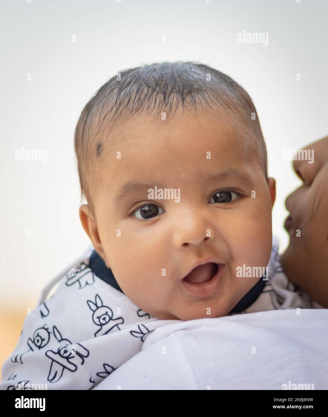 cute infant facial expression resting at mother shoulder from flat ...