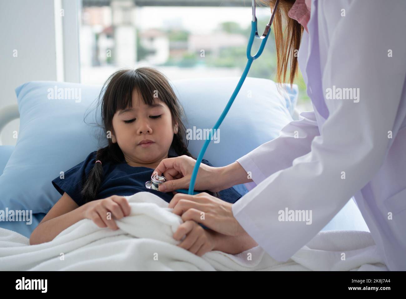 Asian woman pediatrician doctor hold stethoscope for exam a little girl ...
