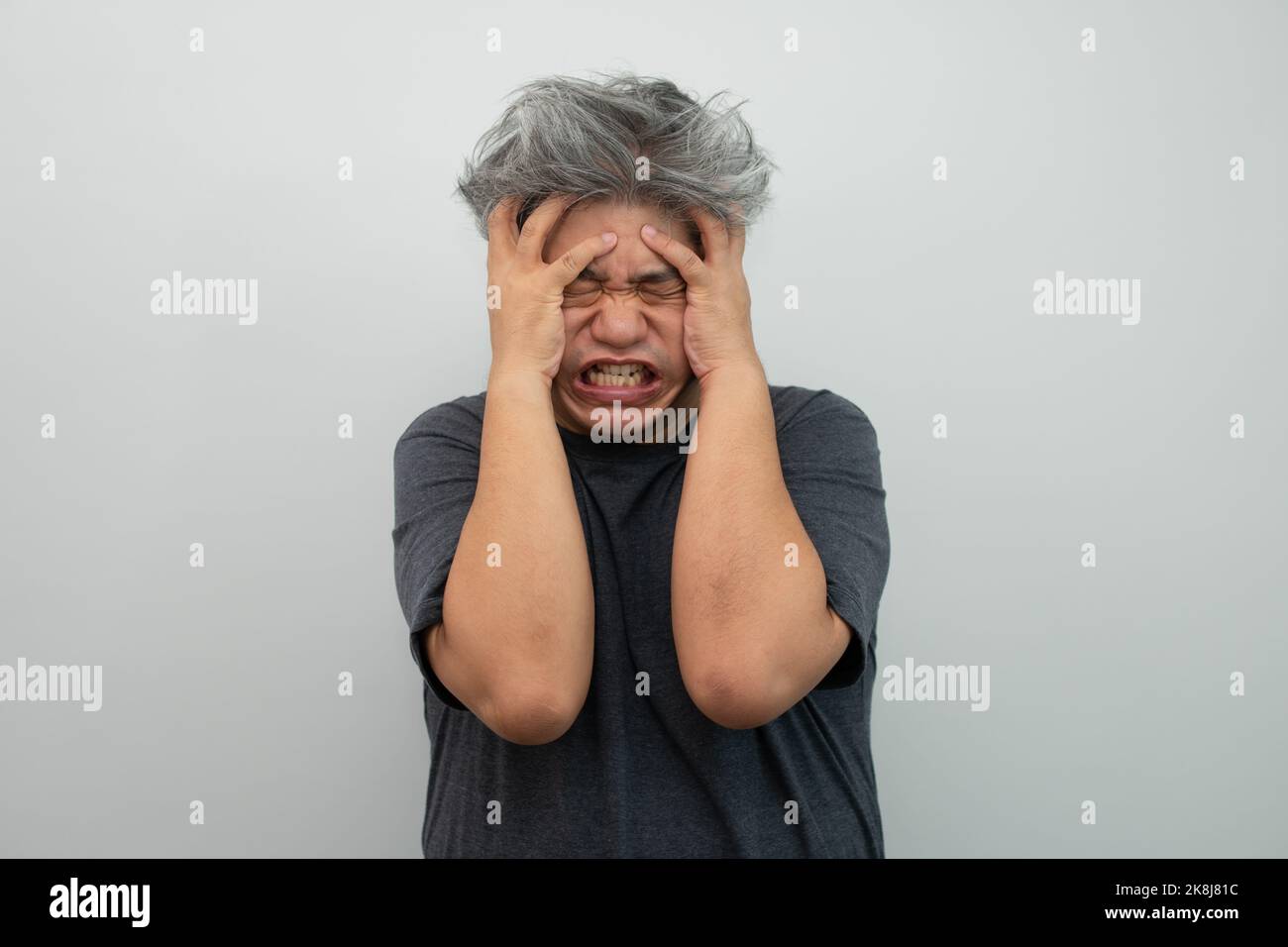 Portrait of a furious senior grey-haired man yelling and screaming and ...