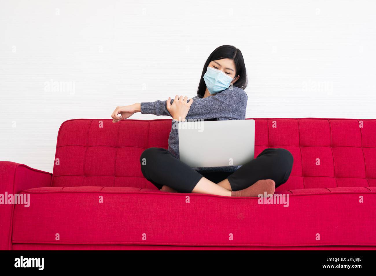 Tired woman wearing a face mask, pain in neck tensed muscles and ...