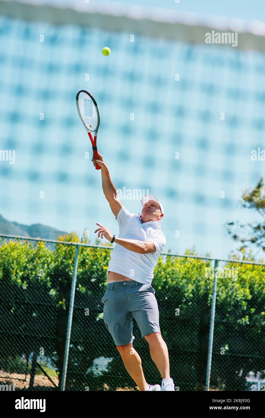 I have a passion for tennis. a handsome mature man playing tennis alone ...