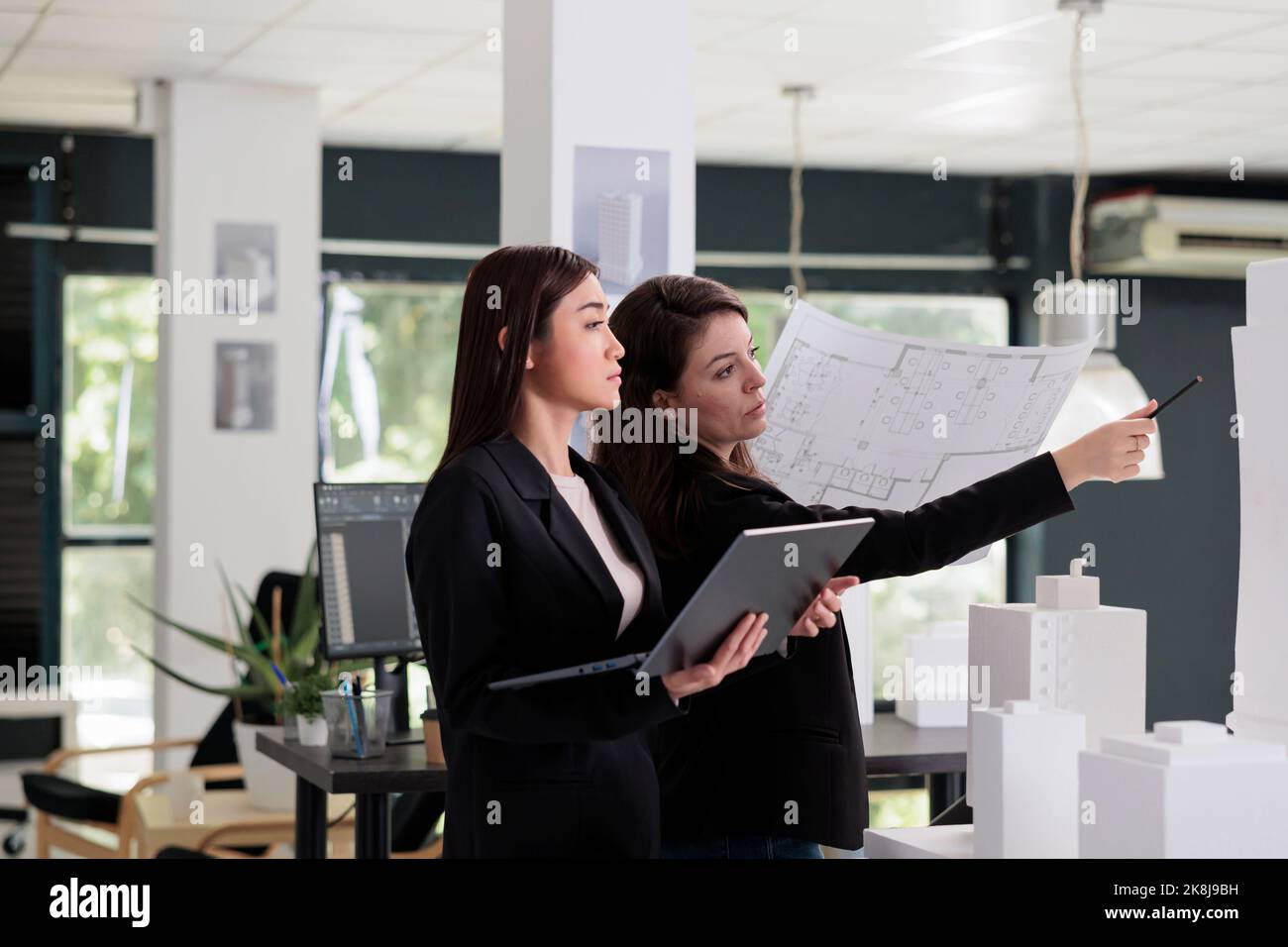 Architects holding blueprint, working with building construction ...